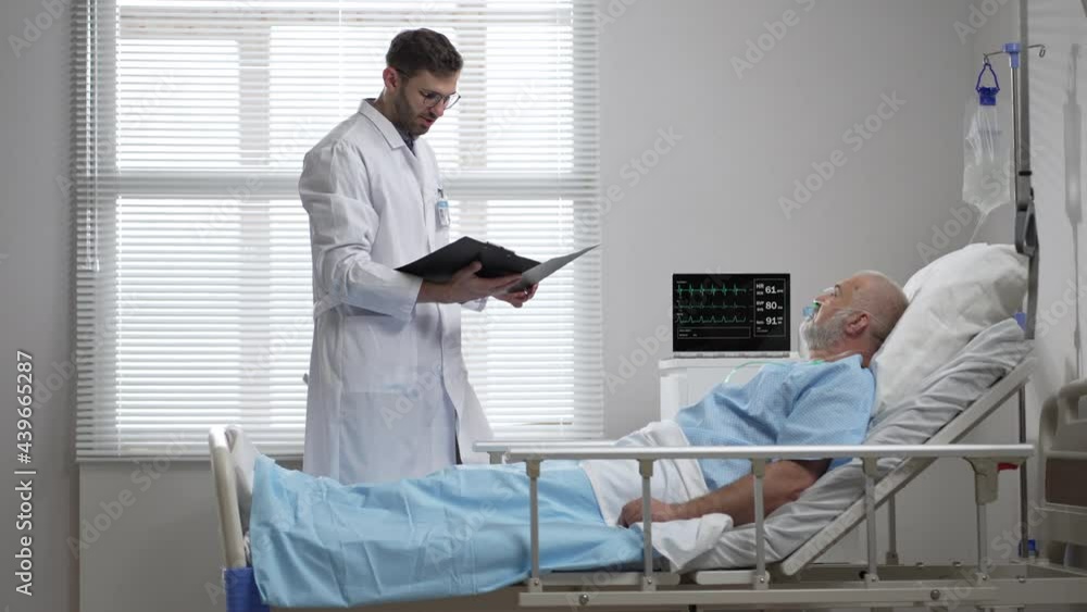 Young doctor talking to senior man resting in hospital bed. Male RN ...