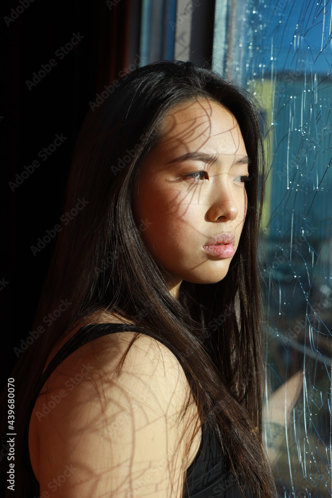 young Asian female behind broken glass window Stock Photo | Adobe Stock