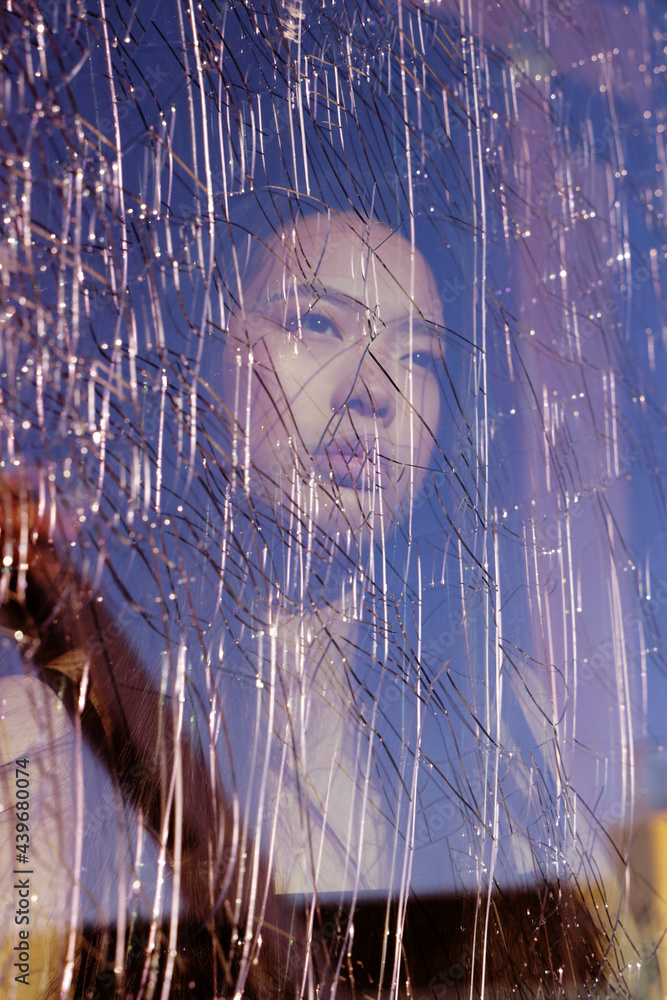 young Chinese woman behind broken glass window Stock Photo | Adobe Stock