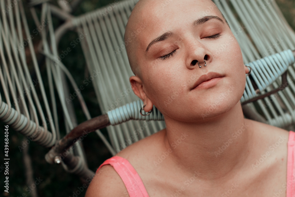 Emotional portrait of a beautiful bald woman lying in a garden Stock ...