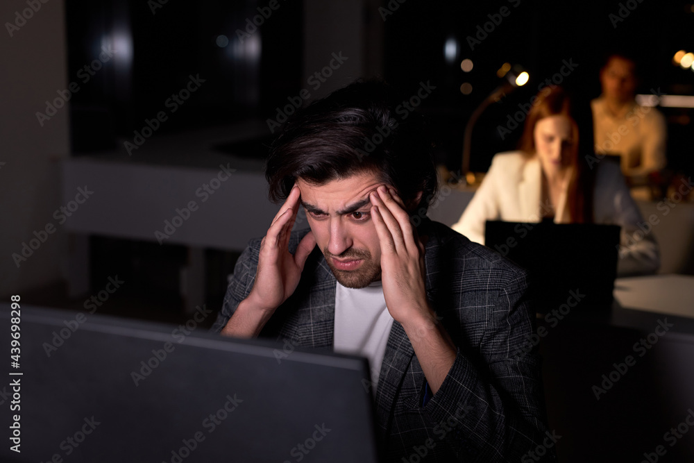 Fotografia do Stock: Portrait of tired male in suit sitting at desk in ...