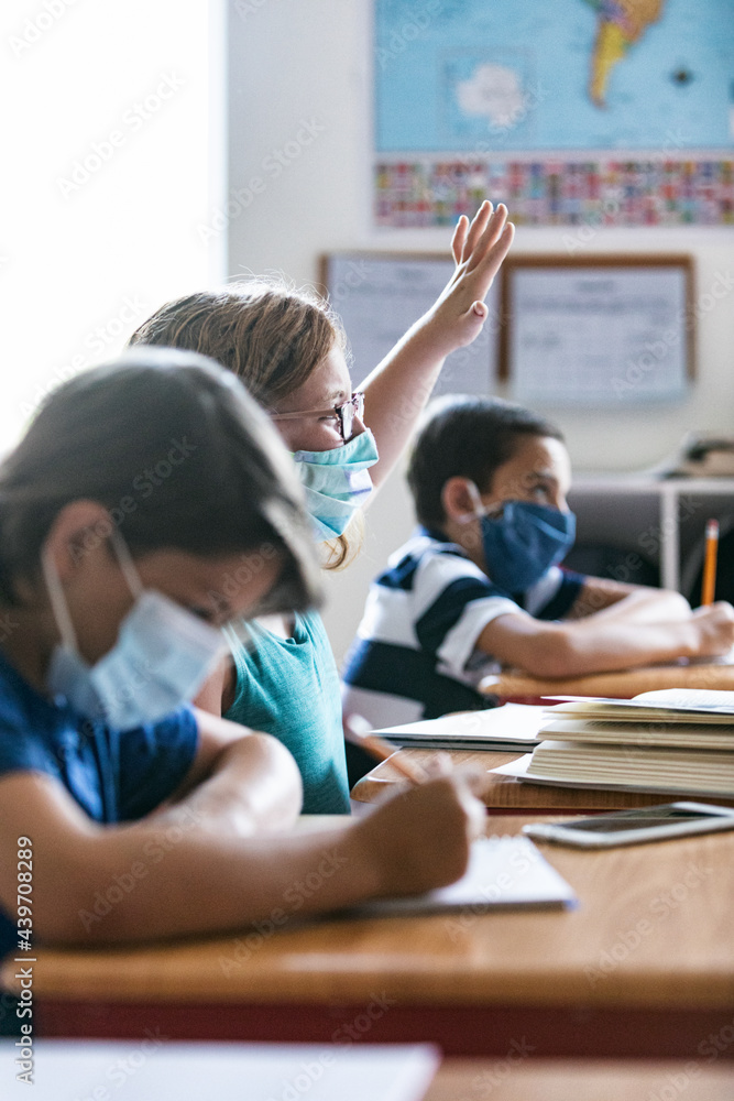 School: Girl Student With Face Mask Raises Hand Stock Photo | Adobe Stock