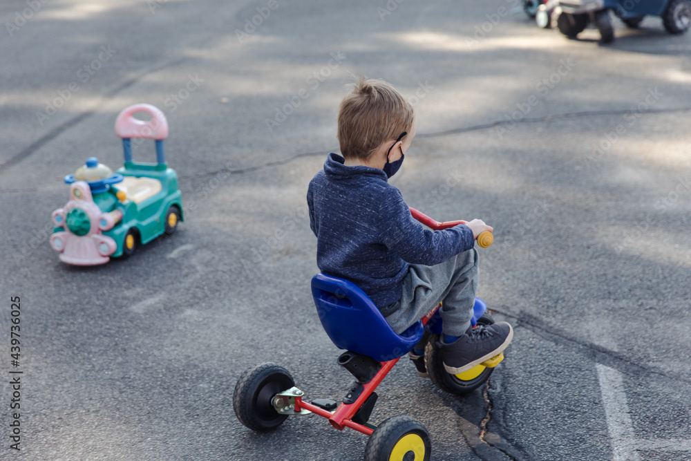 Little boy riding a tricycle Stock Photo | Adobe Stock