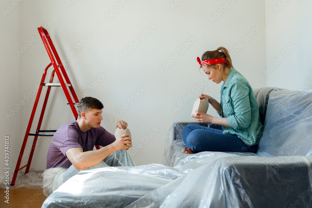 Couple having lunch in messy room during renovation works Stock Photo ...