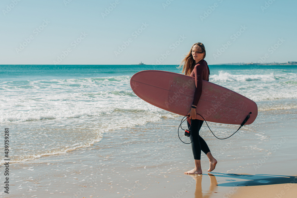 Female surfer at the beach during sunny day Stock Photo | Adobe Stock