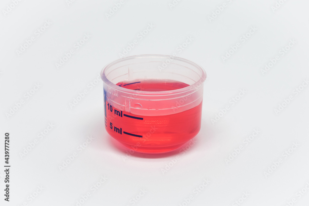 Measuring cup for syrup, cough syrup, medicine, red syrup in cup, white ...