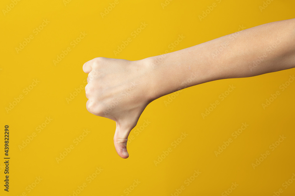 Teen hand gesture with closed fist held with and thumb extended ...