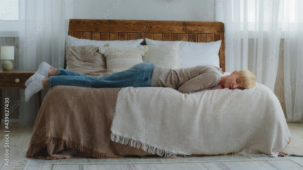 Exhausted bored young woman falling down on bed in bedroom. Pretty ...