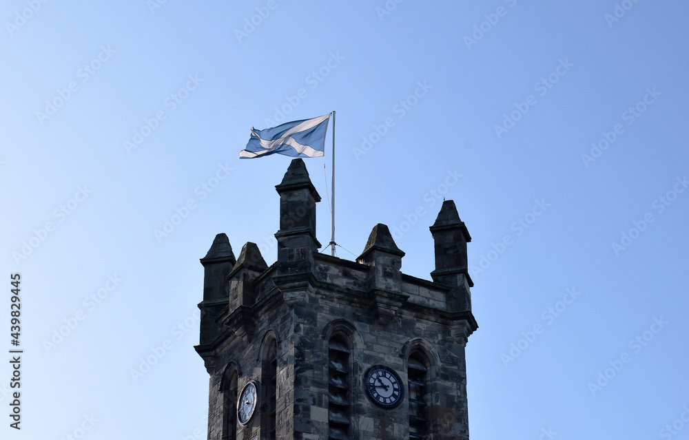 Old Stone Tower with Finials & Clock with Pole & Flag against Blue Sky ...