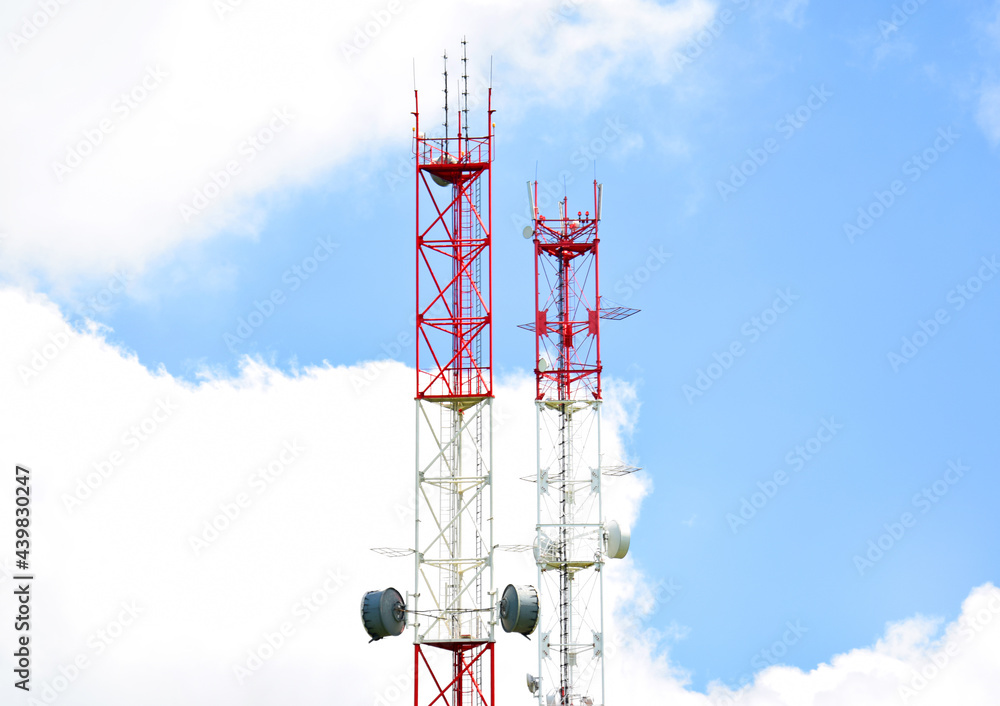 Two telecommunication towers with radio modules and antennas against a ...