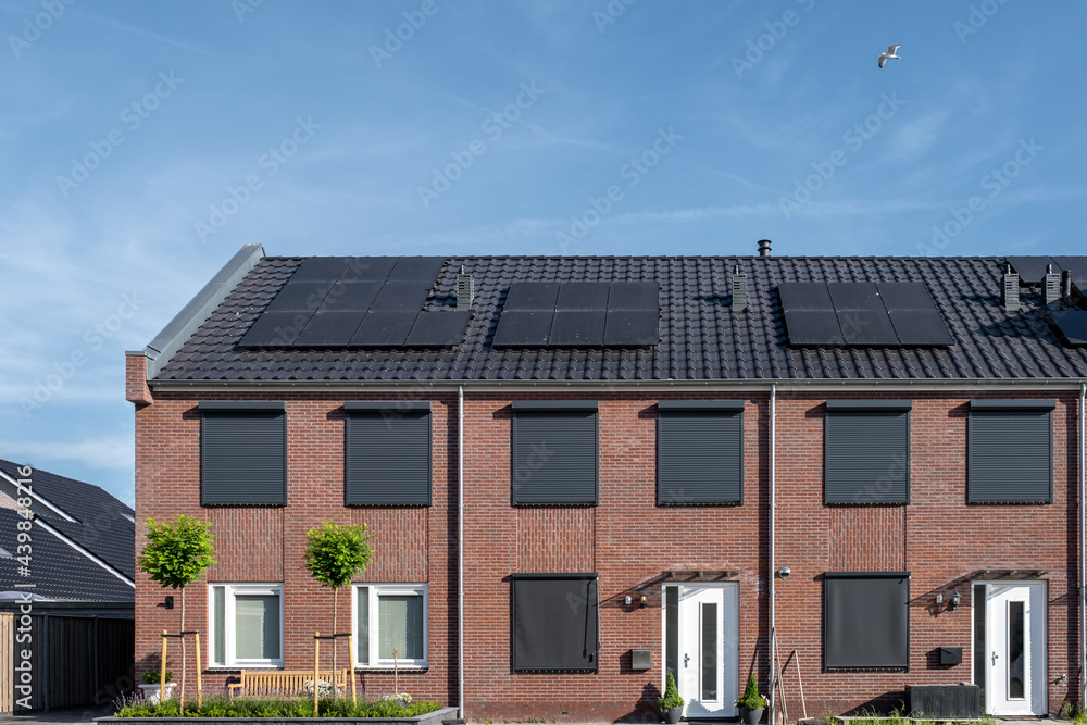 Newly build houses with solar panels attached on the roof against a ...