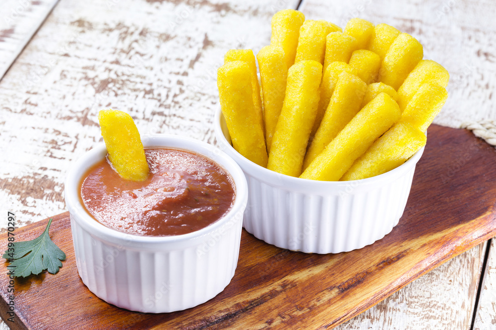 Brazilian snack called polenta, served with sauce and ketchup, isolated ...