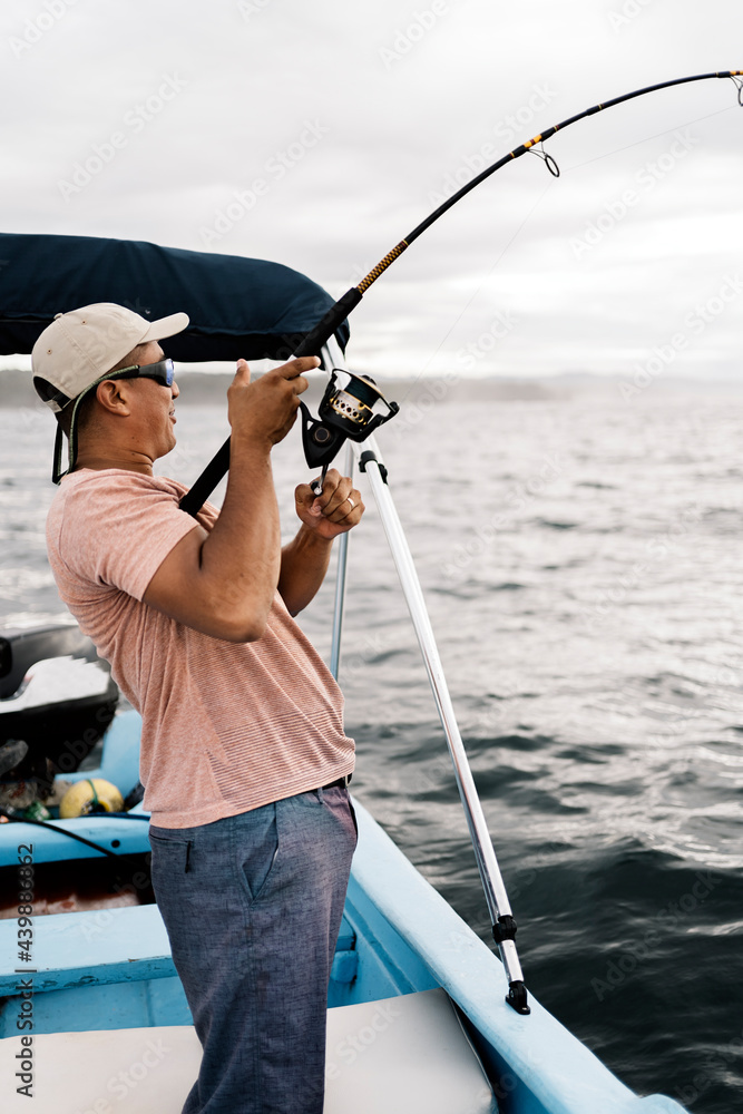 Fisherman Using Fishing Rod Stock Photo | Adobe Stock