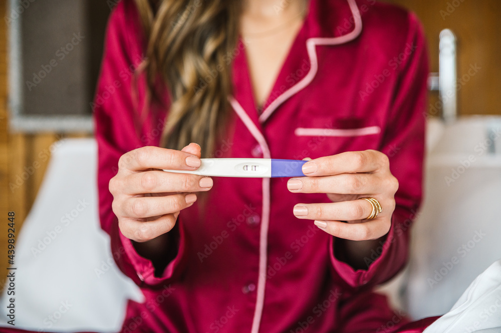 Woman demonstrating positive pregnancy test Stock Photo | Adobe Stock