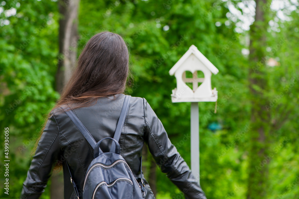 girl walks in an spring park, young lady back view. woman in black ...