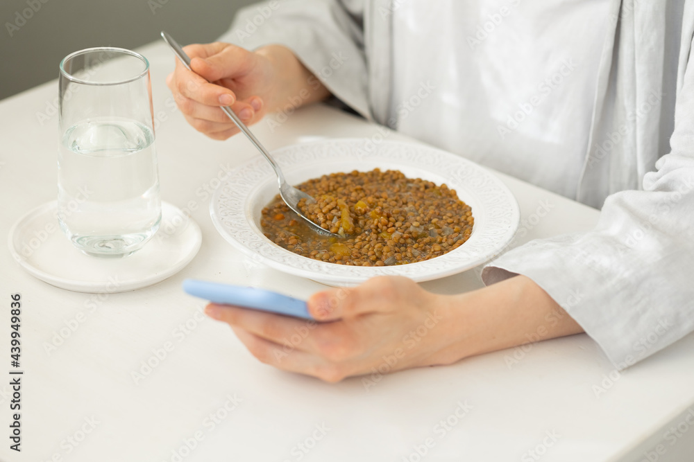 Caucasian woman eats lunch with her phone in her hands,eating and being ...