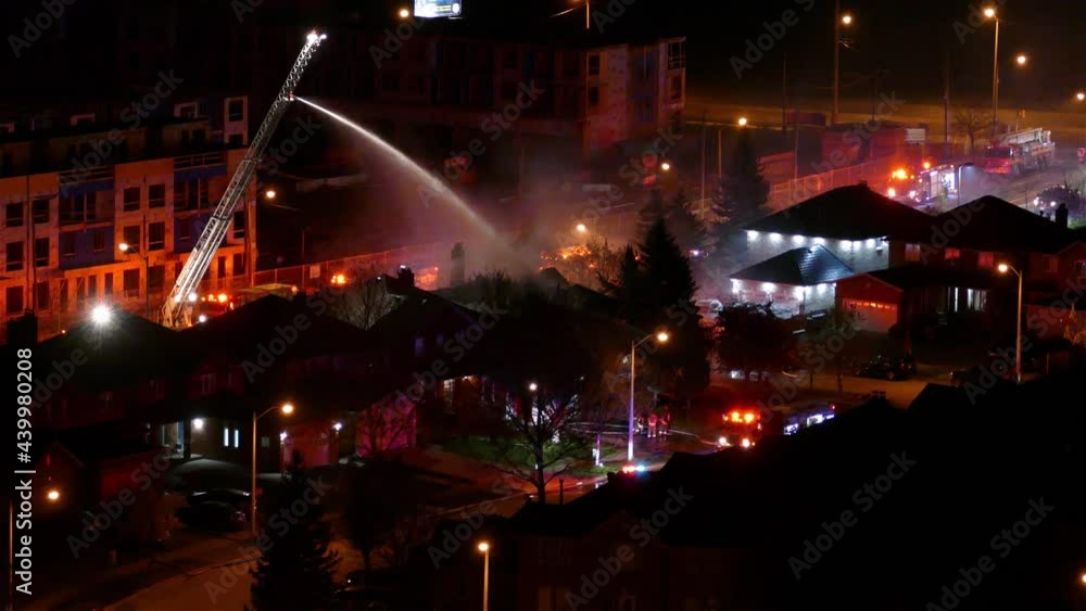 Vidéo Stock Fire brigade unit watering burnt house from crane in an ...