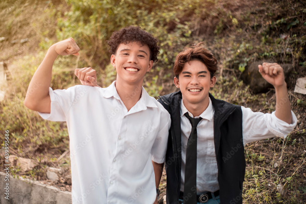 Two young asian men have fun and pose with their arms flexed for the ...