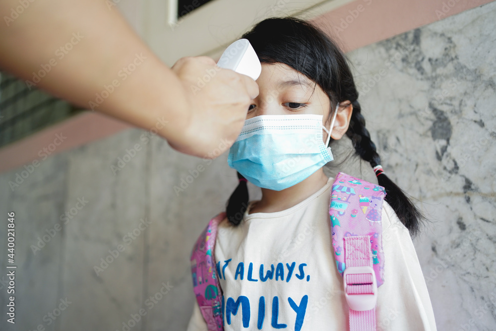 temperature check in school kid girl at school. Asian girl measuring ...