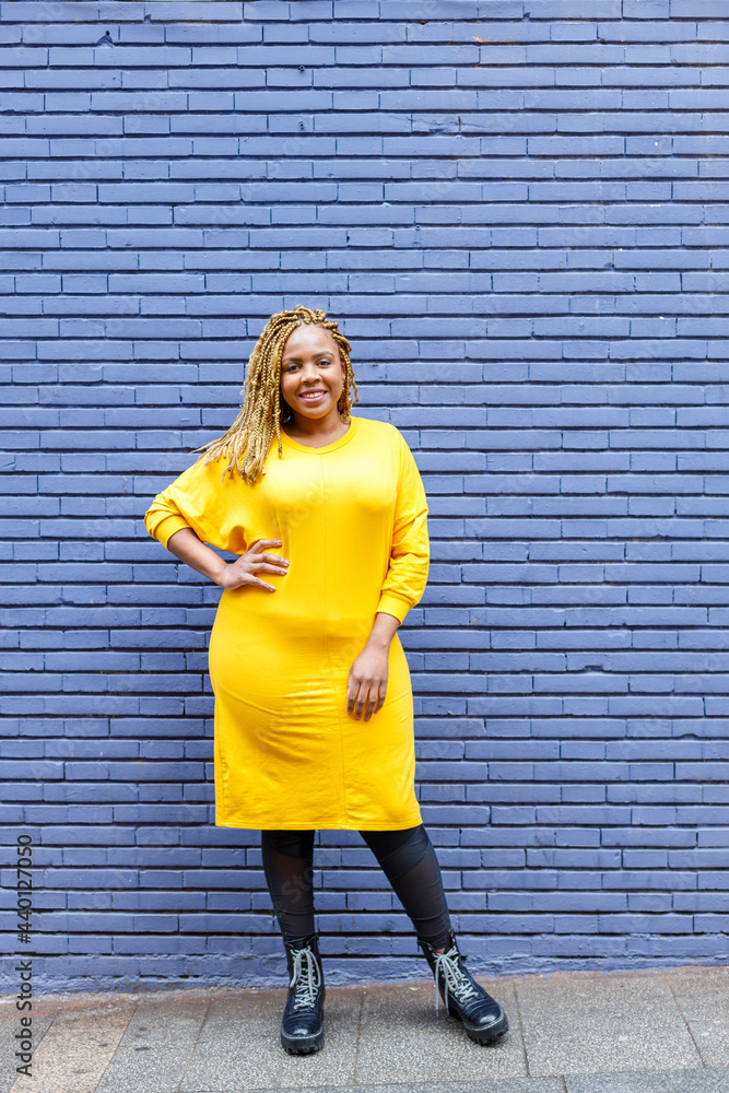 Confident plus size woman standing with hand on hip in front of ...