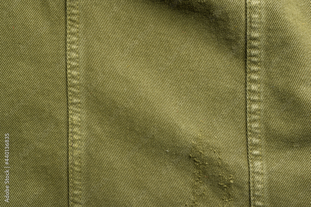 Deep moss green denim fabric with wavy texture, parallell seams and ...