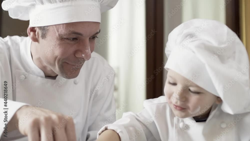 Dad and son playing with flour while cooking cake. Family activities ...