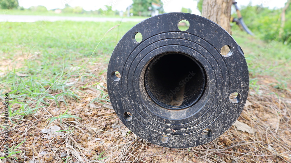 flanges on black plastic pipes. Dirty old flange of a water pipe on the ...
