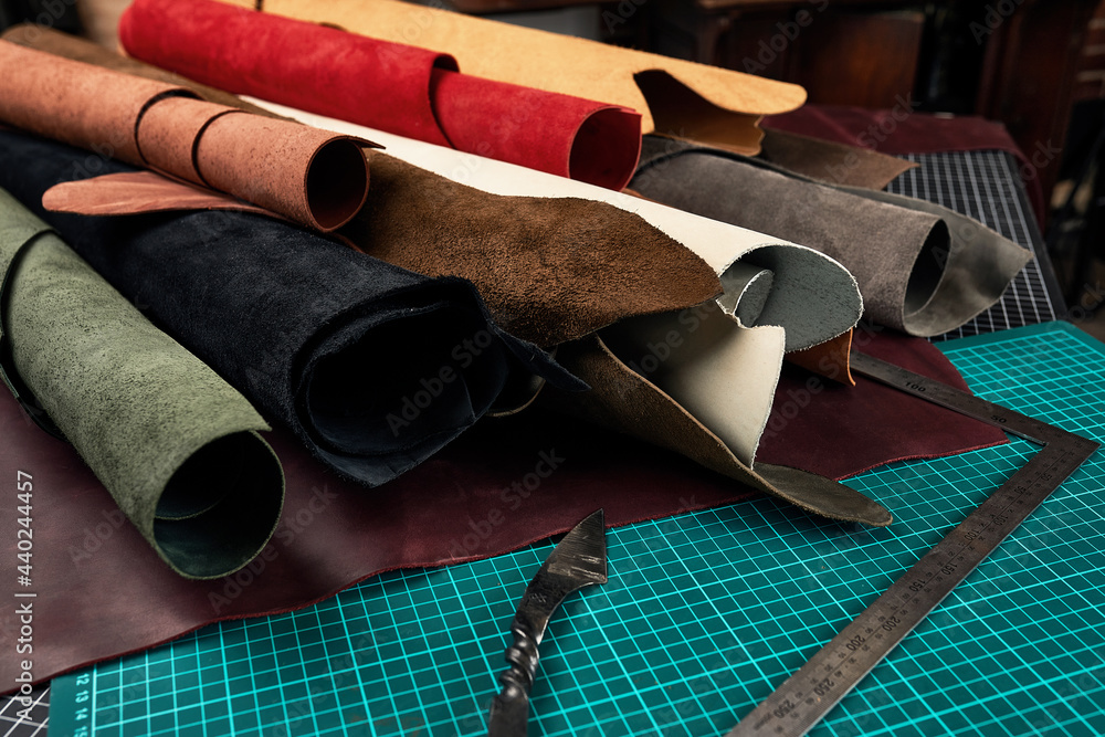 Rolled up samples of textures of genuine leather of different colors on ...