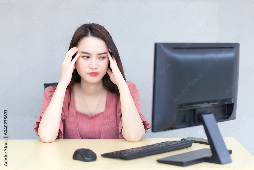 Asian professional business woman who wears pink dress is working tired ...