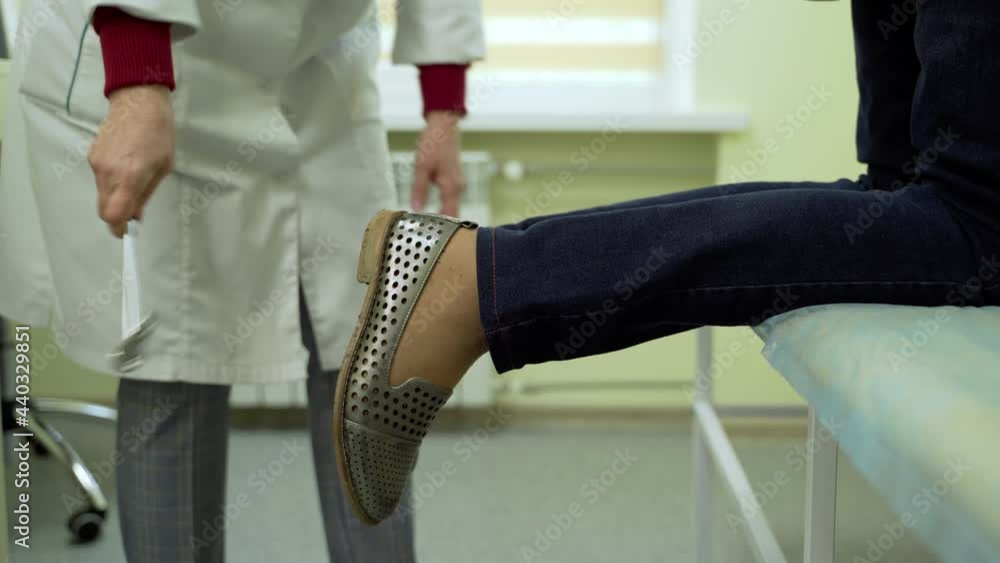 Checking up reflexes with hammer. Doctor checking reflexes of patient ...