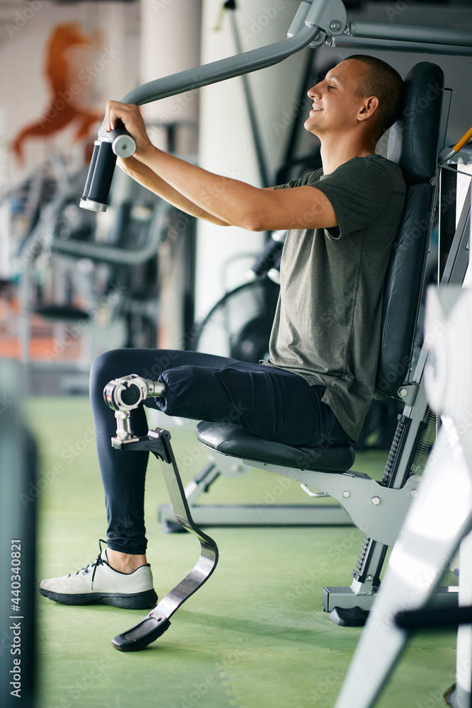 Happy amputee doing exercises for upper body strength on exercise ...
