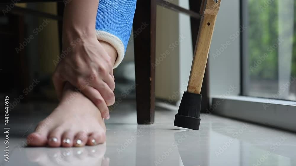 injury woman wearing blue leg splint sitting on chair and holding ...