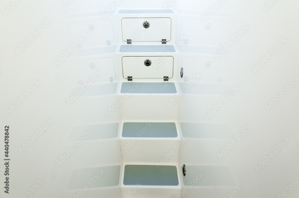 White steps inside a luxury white yacht with a reflection of steps on ...