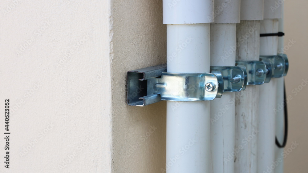 Clamp the conduits on the wall. Installation of IMC plastic conduit on ...