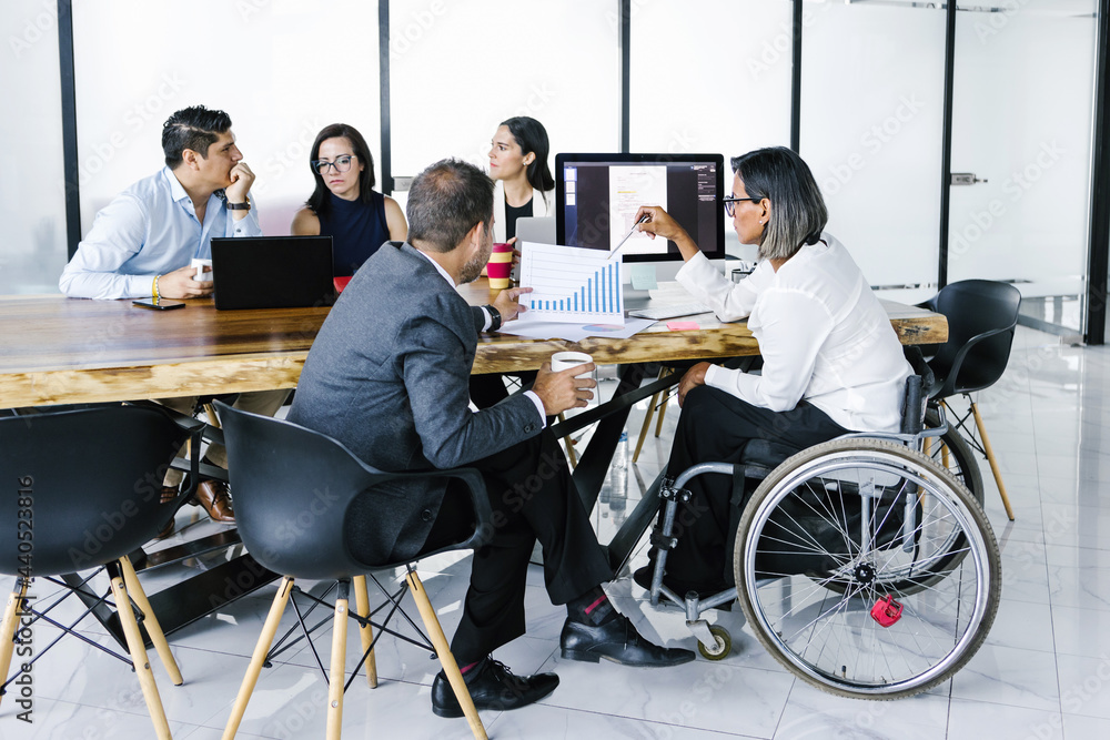 Hispanic disabled transgender woman and office workers analyzing ...