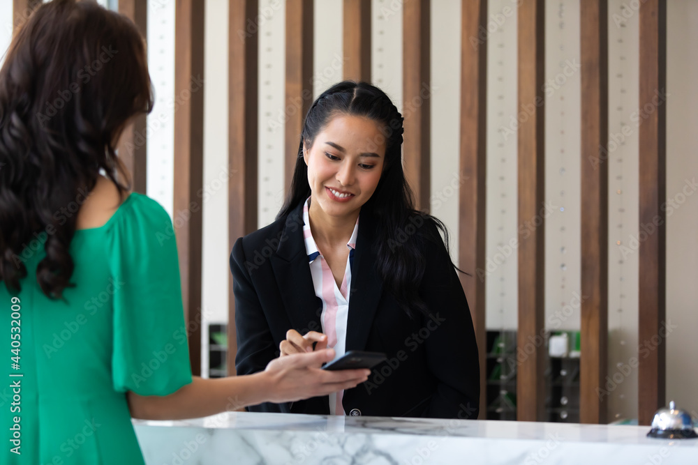 Friendly receptionist woman working at desk in hotel lobby. Leisure and ...