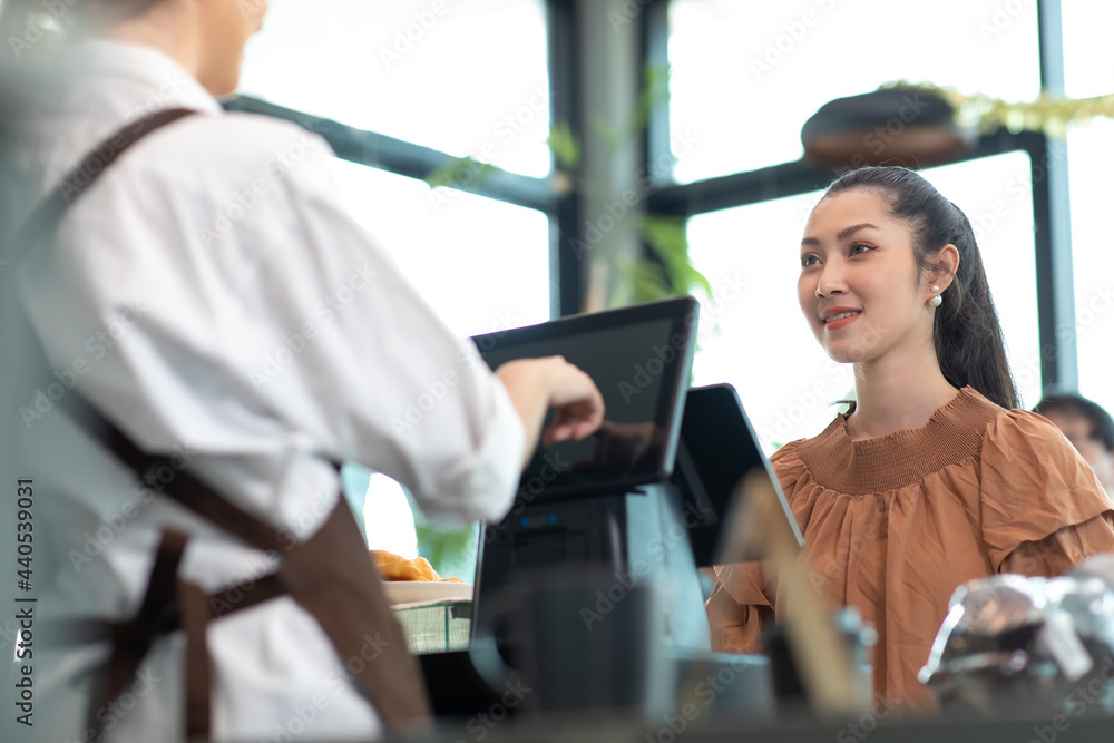 Asian young woman customer is ordering coffee from an automatic machine ...