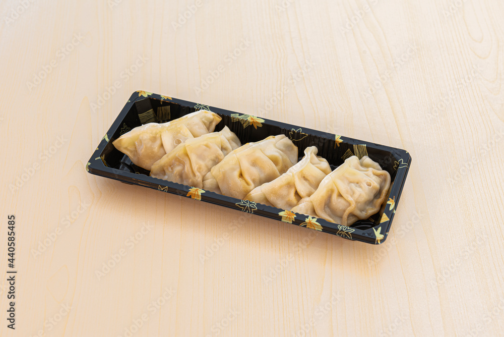 Ration of steamed gyoza dumplings in a plastic container for home ...