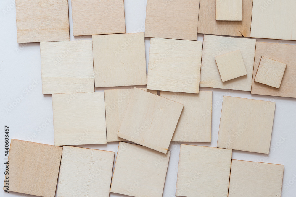 laser cut untreated or natural square wooden shapes arranged on a light ...