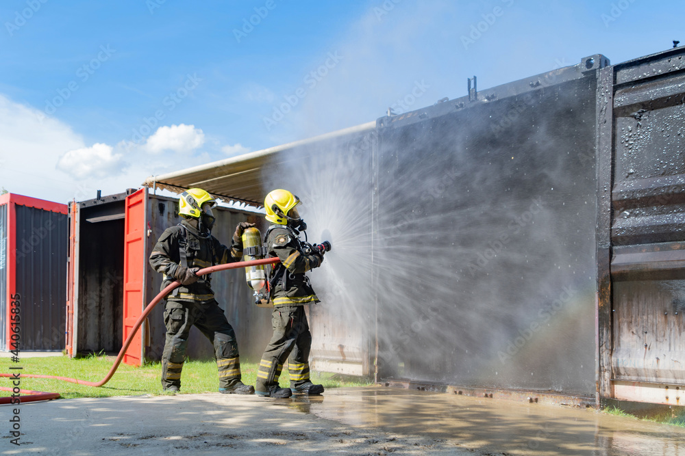 A group of firefighter or fireman with uniform using water fire hose ...