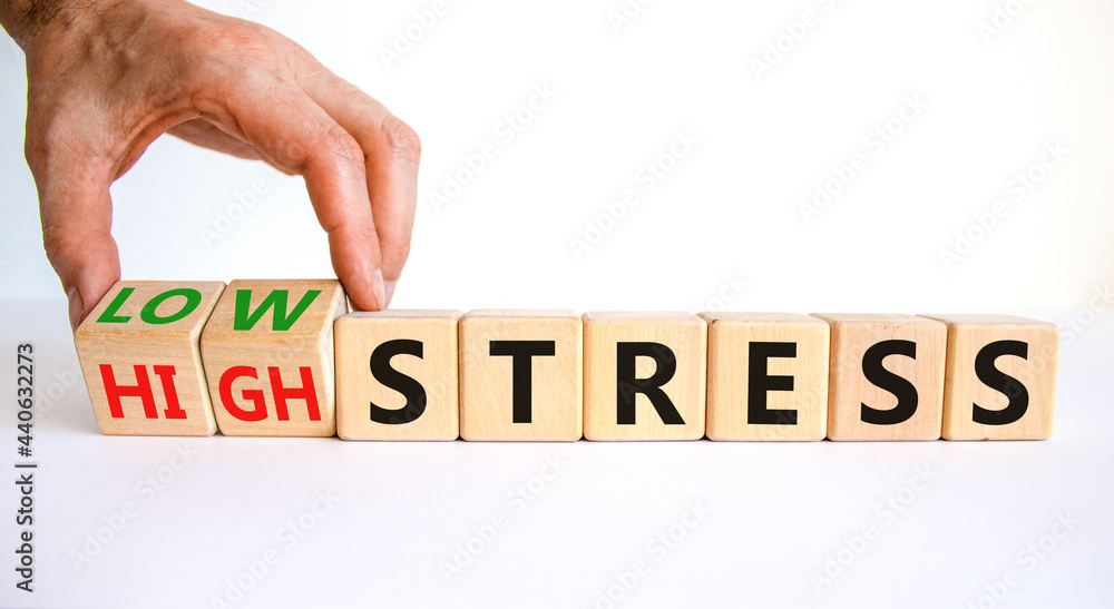 Foto de Low or high stress level symbol. Businessman turns wooden cubes ...