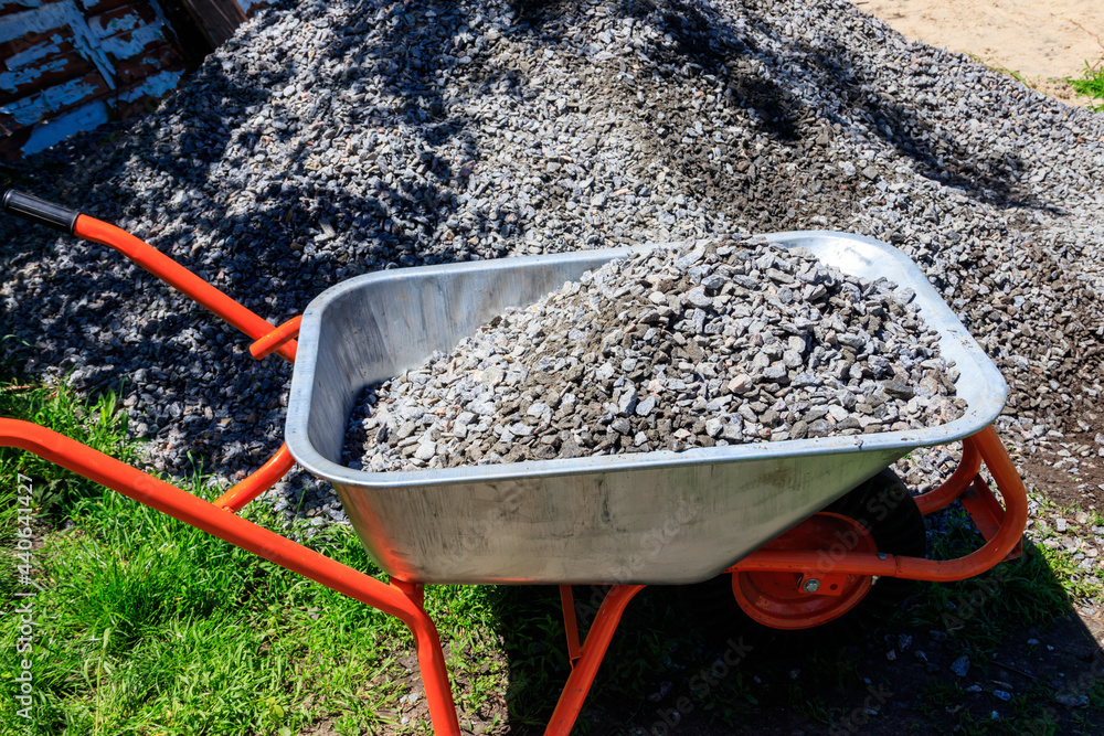 Wheelbarrow with gravel at the construction site Stock Photo | Adobe Stock