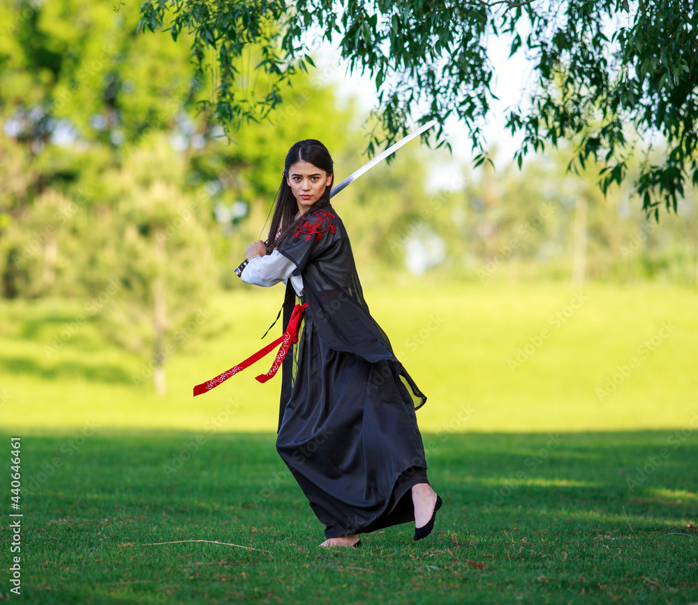 Young asian woman in traditional kimono trains fighting techniques with ...