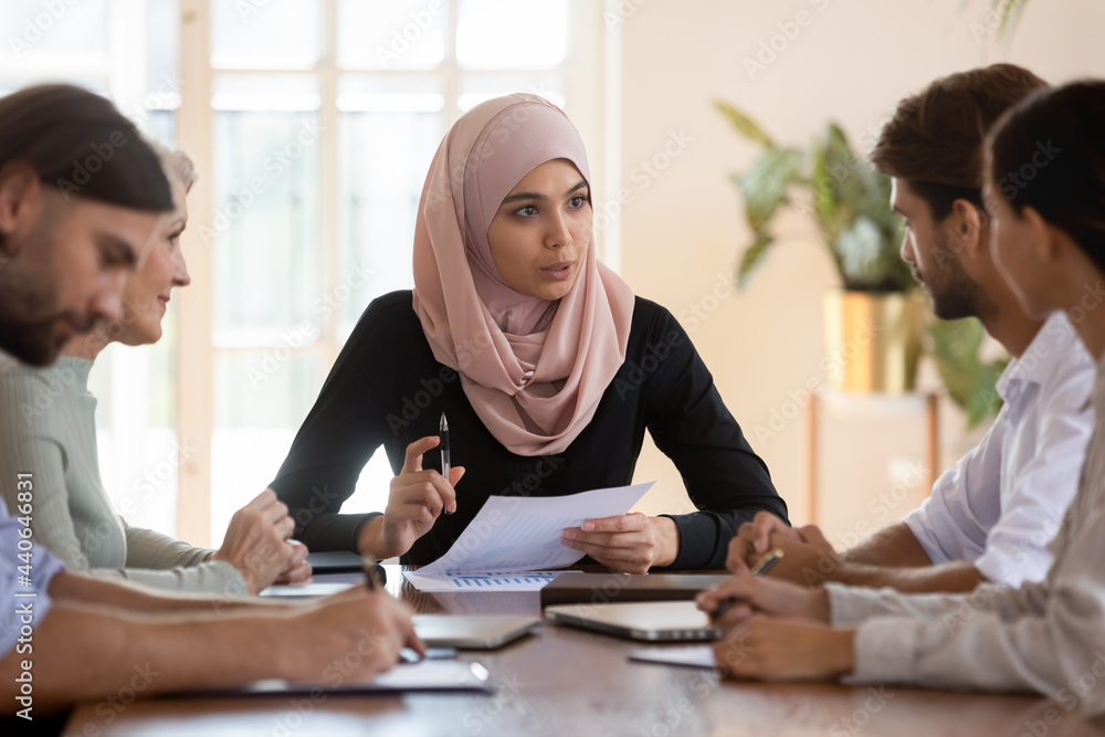 Confident Asian muslim female team leader holding corporate meeting ...