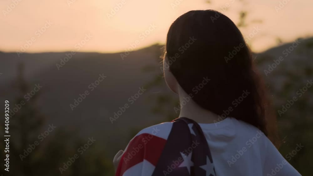 Independence Day. A young woman with an American flag draped over her ...