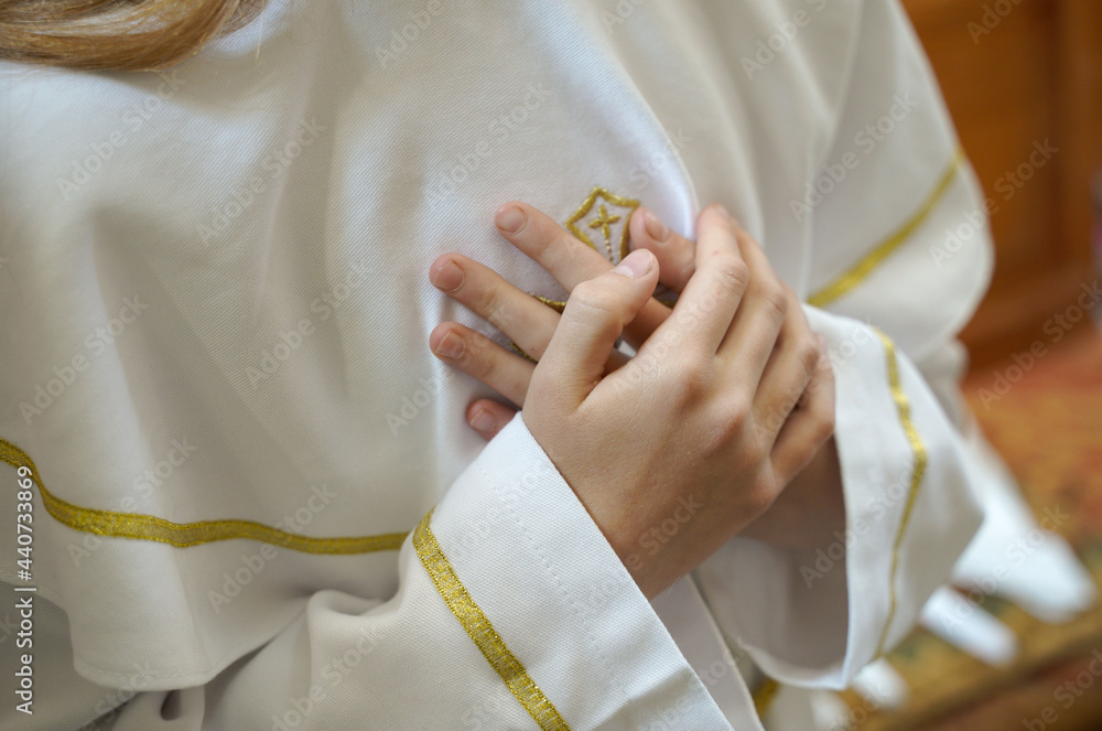 folded hands of a child on the heart before receiving Holy Communion ...