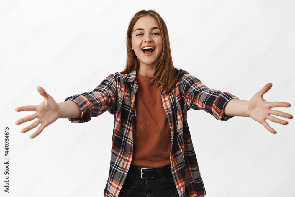 Welcome. Hostile happy girl extends hands in warm welcome, smiling and ...