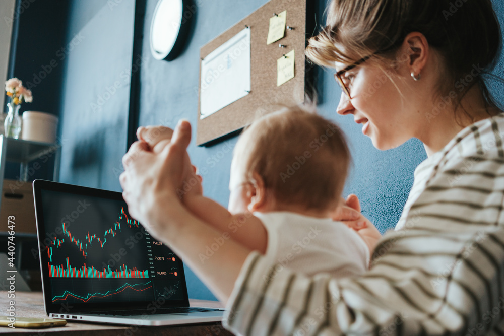 Handsome woman with her cute baby investing in world stock market ...