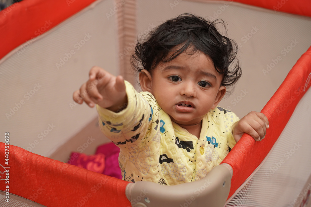 Indian baby boy standing in his playpen and pointing something Stock ...