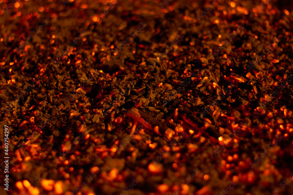 The hot coals of a bonfire flicker in the dark. Burning coals in a ...